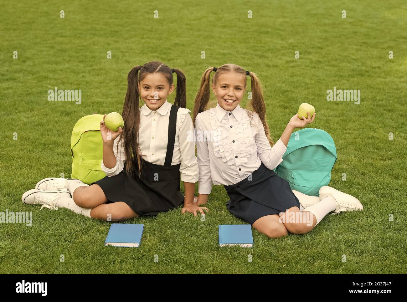School friends relaxing after classes at school yard, lunch time ...