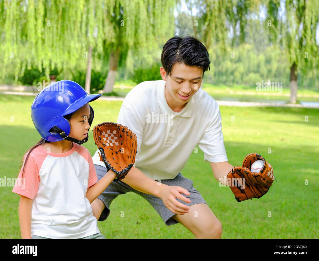 Happy father and daughter are playing baseball in the park high quality ...