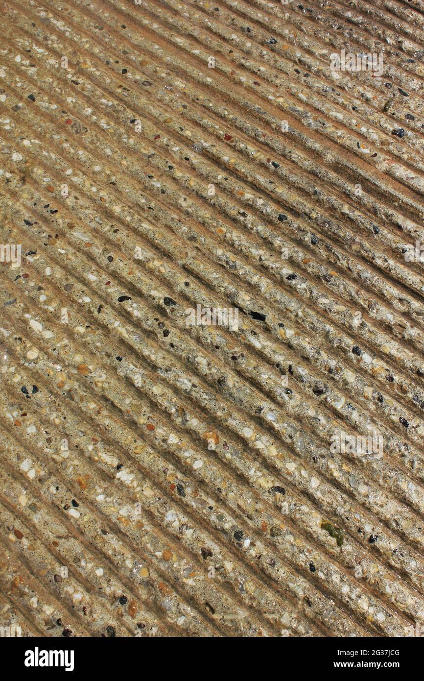 Shallow water waves rolling along the grooves of a boat ramp during the ...