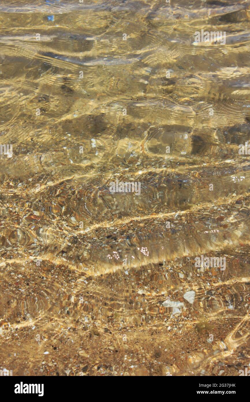 Shallow clear water with small ripples in the waves during the ...