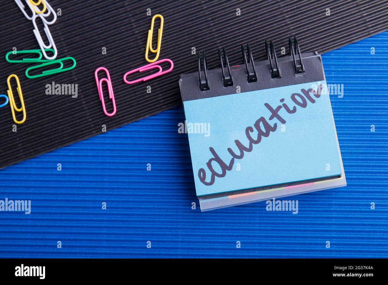 Small note book with education word written on the blue front paper ...