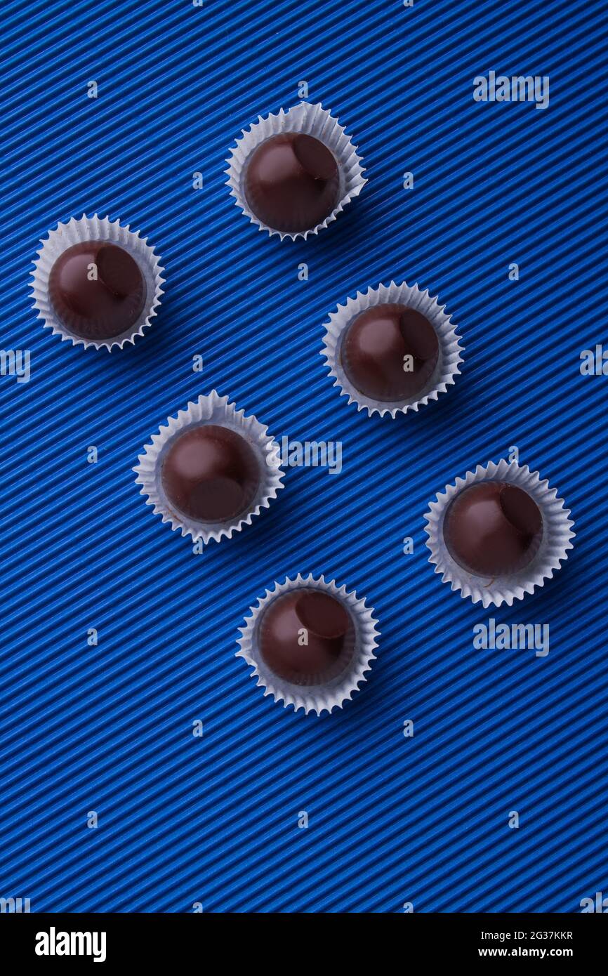 Vertical shot six chocolate candies on blue background Stock Photo - Alamy