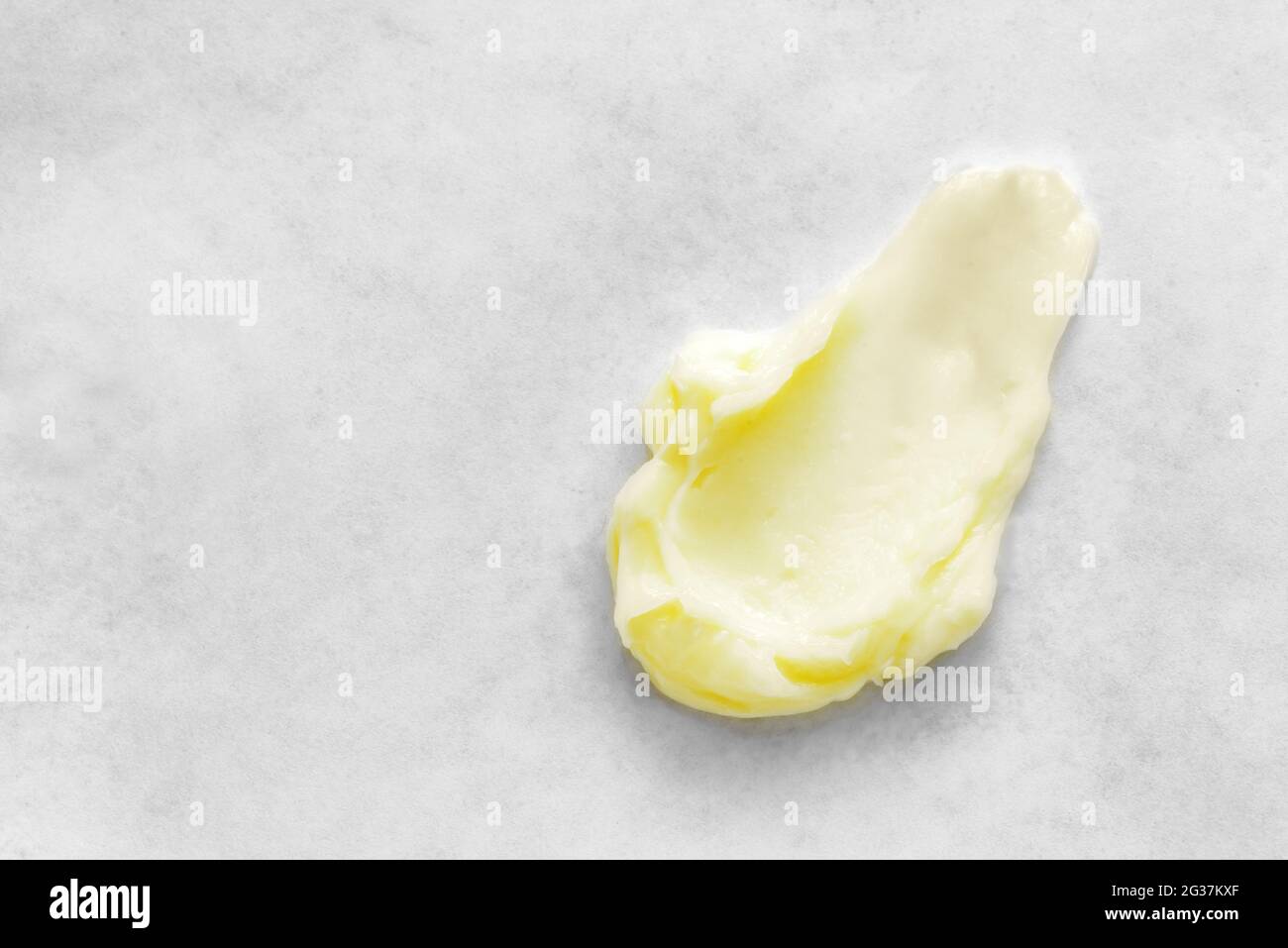 Cosmetic cream gel sample on gray stone background. Yellow primer cream ...