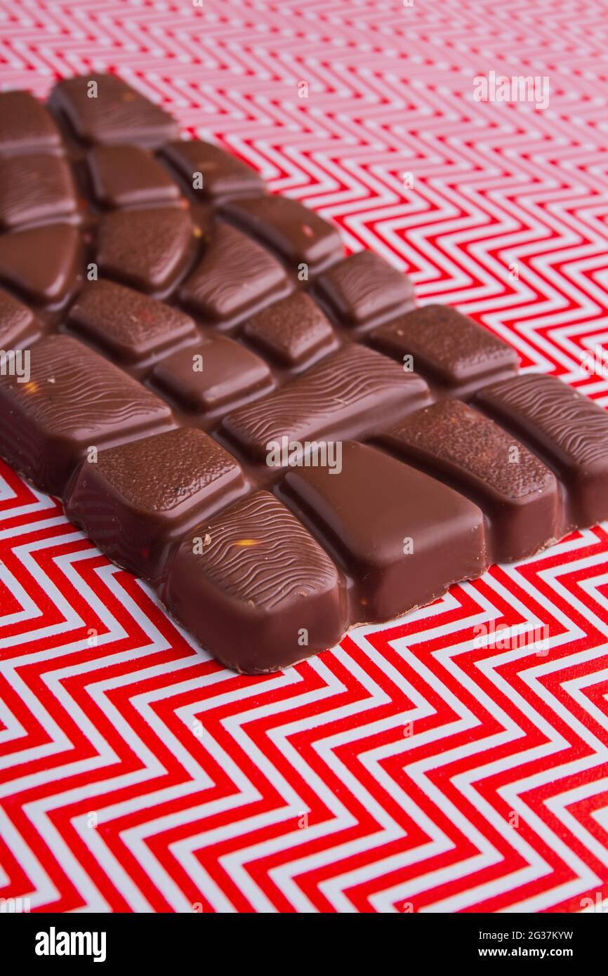 Vertical shot brown chocolate bar on white and red background Stock ...
