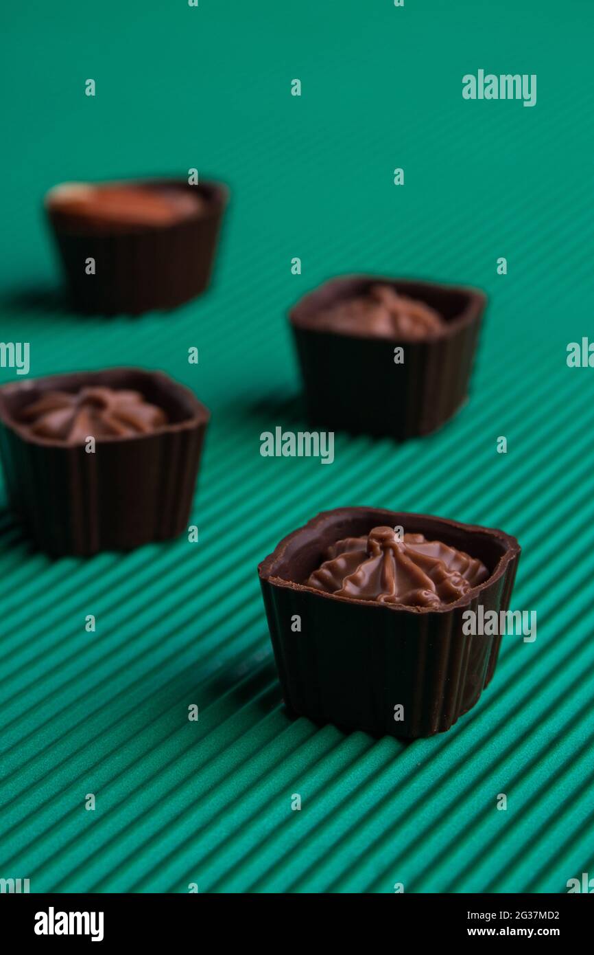 Set of sweet delicious praline brown candies on green background Stock ...
