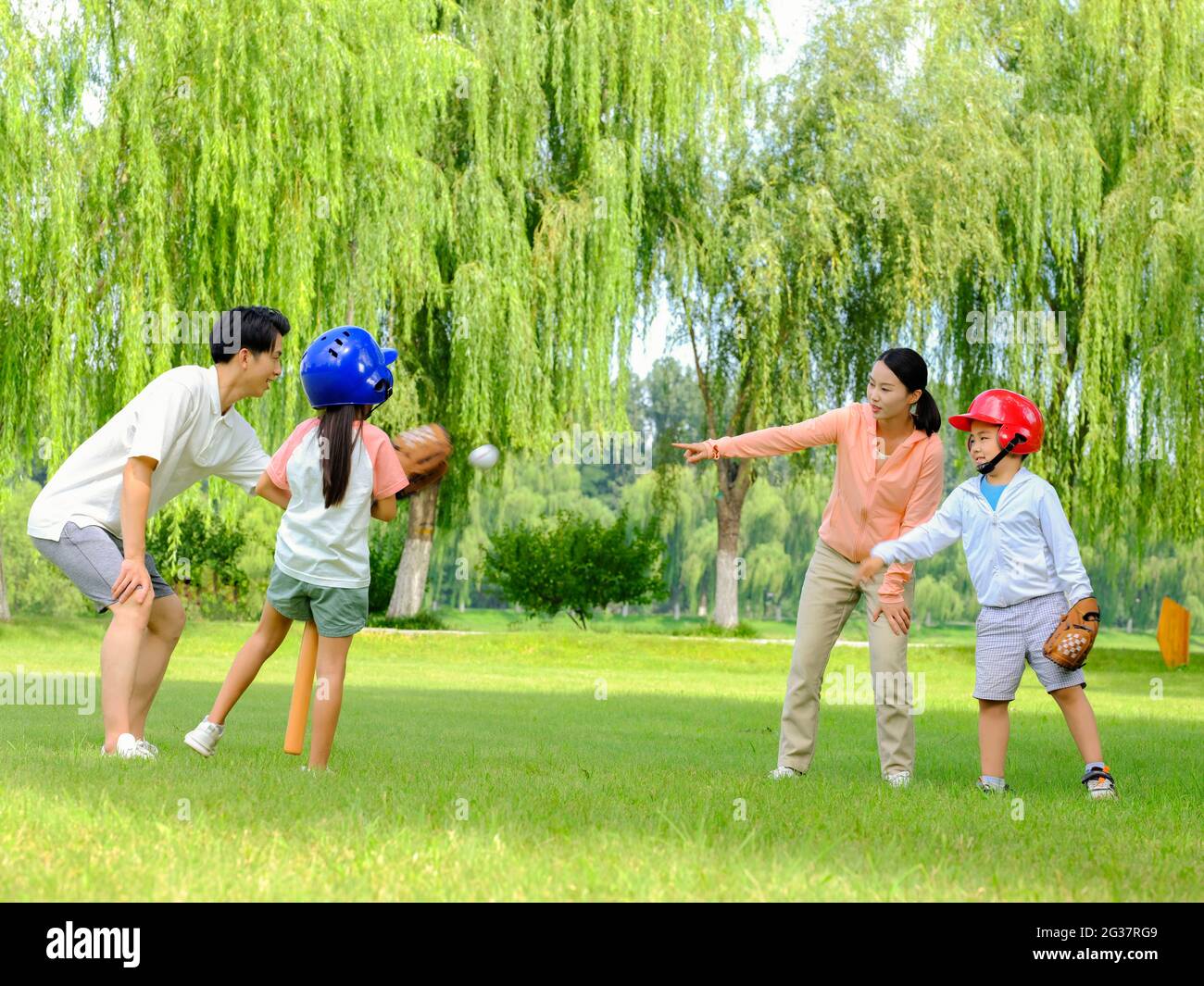 Happy family of four playing baseball in the park high quality photo ...