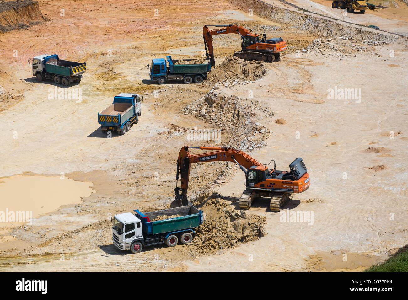 Excavator machines are in sync when digging up the soil and put it on ...