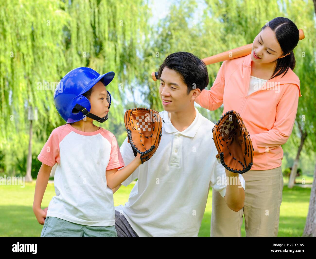 Happy family of three playing baseball in the park high quality photo ...