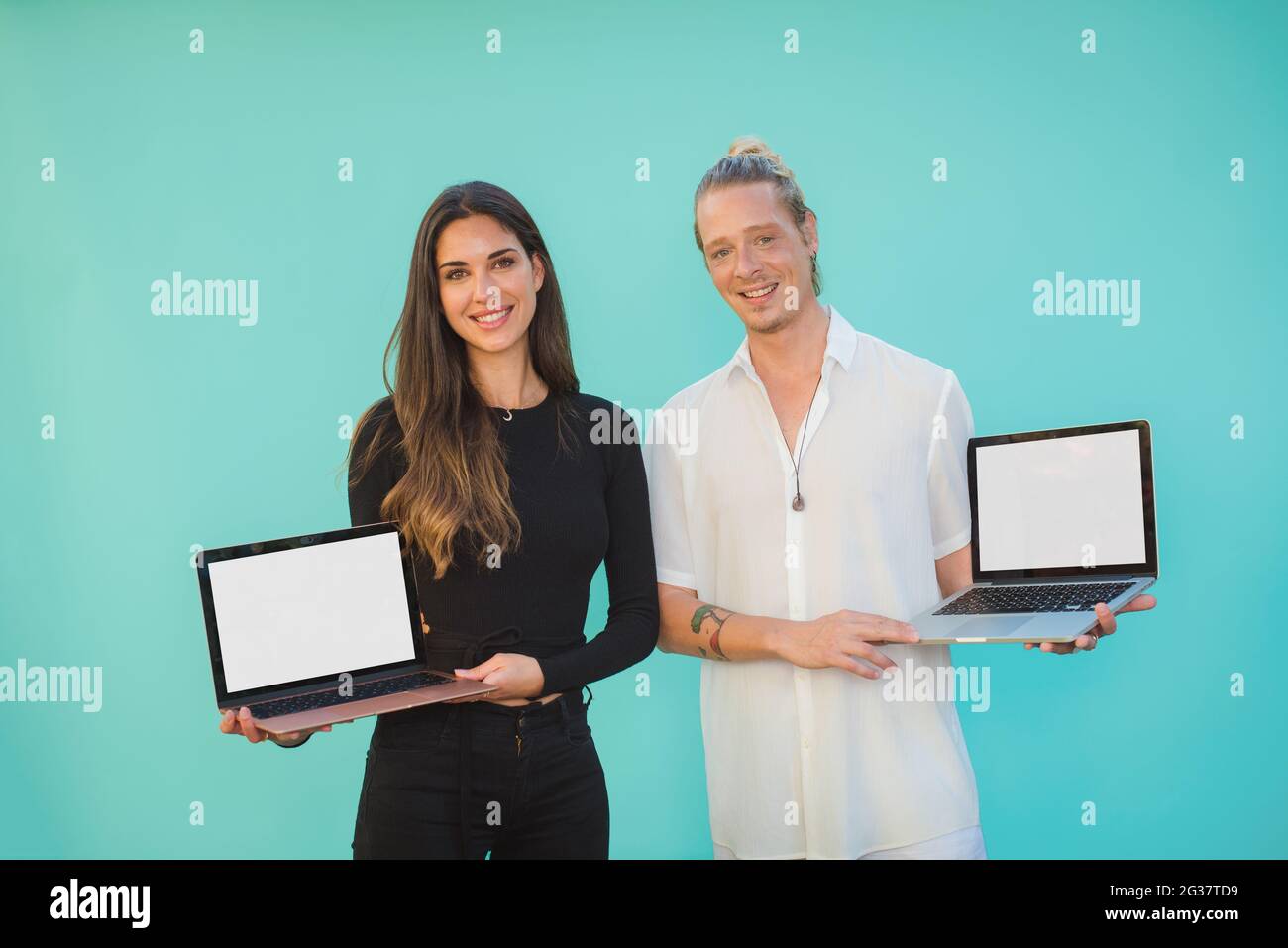 Smiling friends showing laptops with empty screens Stock Photo - Alamy