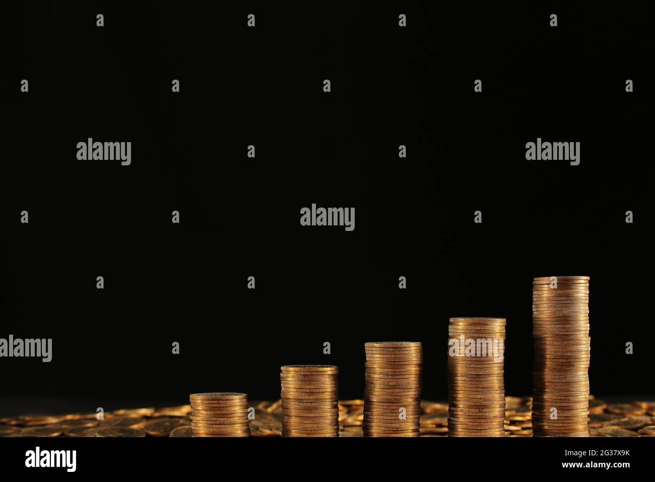 A large variety of coins on a black background. Stack of coins Stock ...
