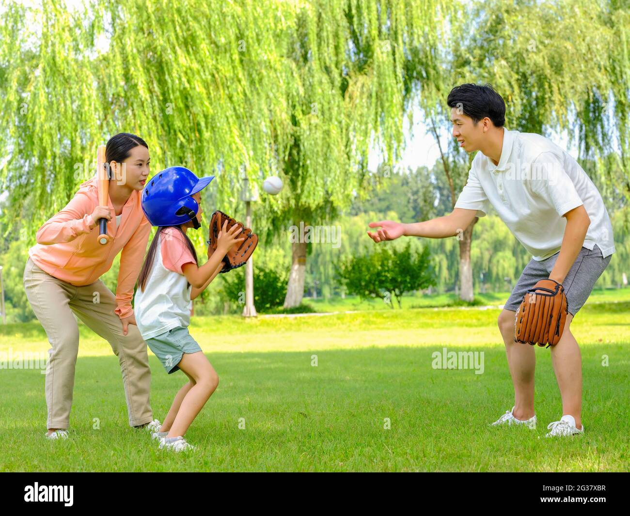 Happy family of three playing baseball in the park high quality photo ...