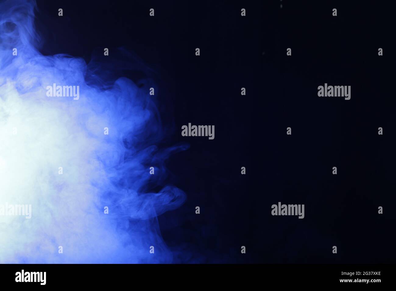 Magic smoke in blue light on black background Stock Photo - Alamy