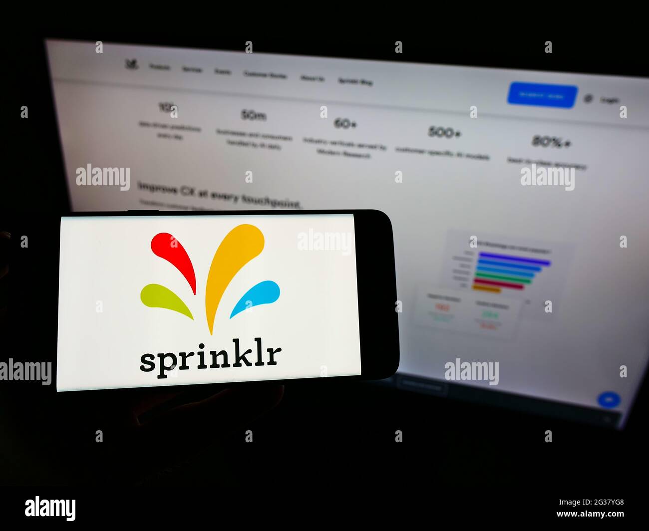 Person holding cellphone with logo of US software company Sprinklr Inc ...