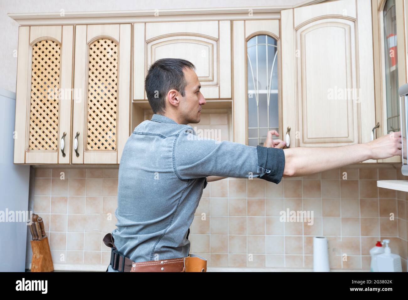kitchen installation. Worker assembling furniture Stock Photo - Alamy