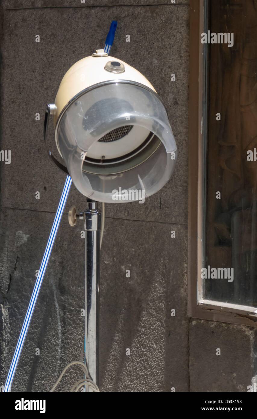 Vintage helmet dryer decorating the exterior of a store in town Stock ...