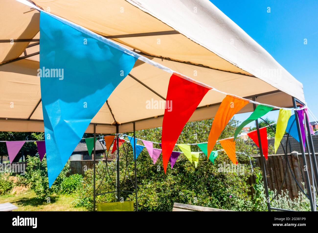 Colourful triangular bunting hangs around the edge of a gazebo as ...