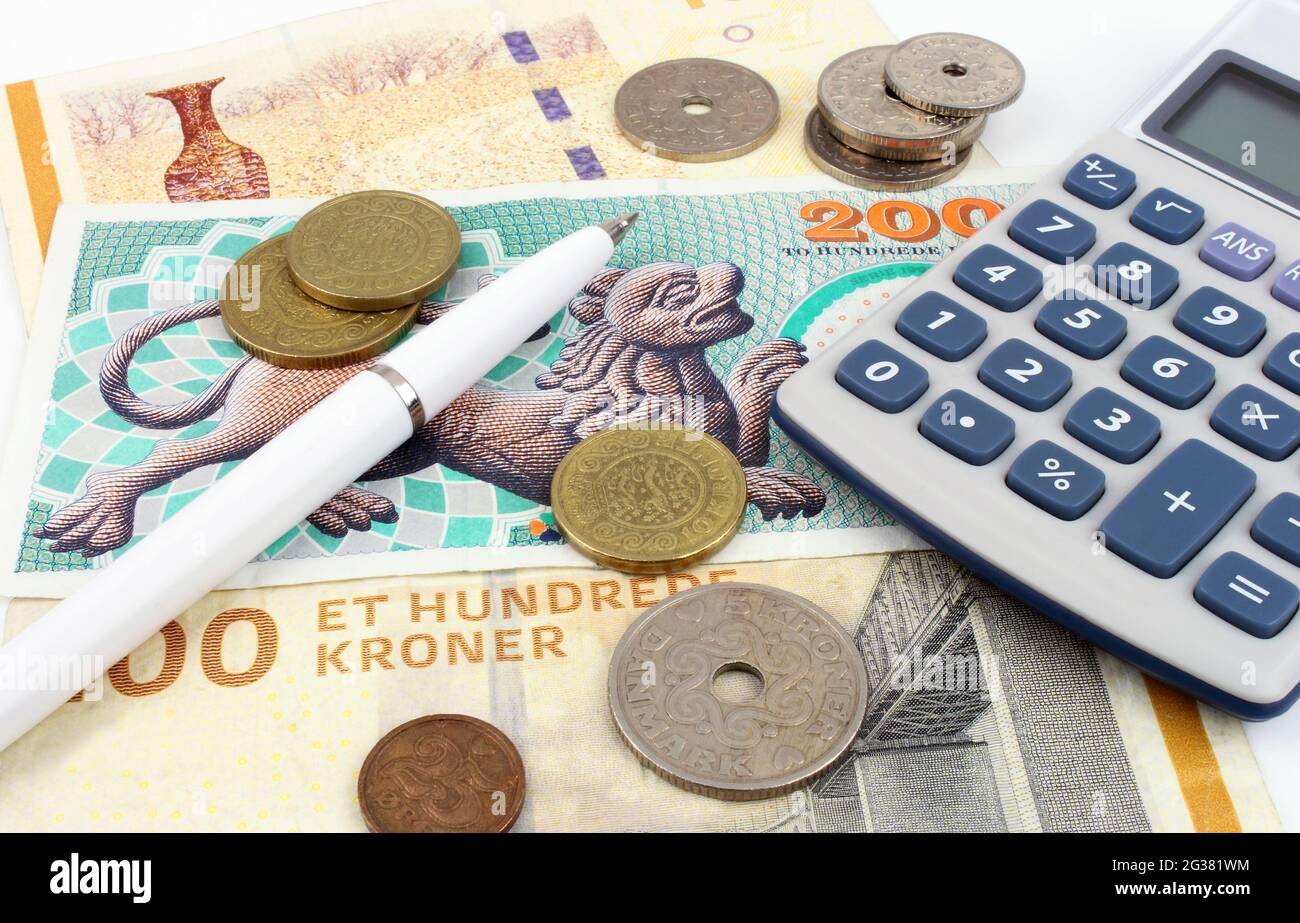 Danish Kroner notes and coins arranged with a calculator and pen to ...
