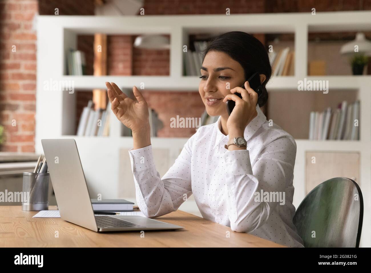Happy young indian woman multitasking in modern office Stock Photo - Alamy