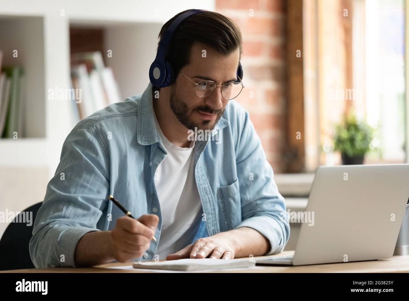 Happy focused young man watching educational lecture on computer Stock ...