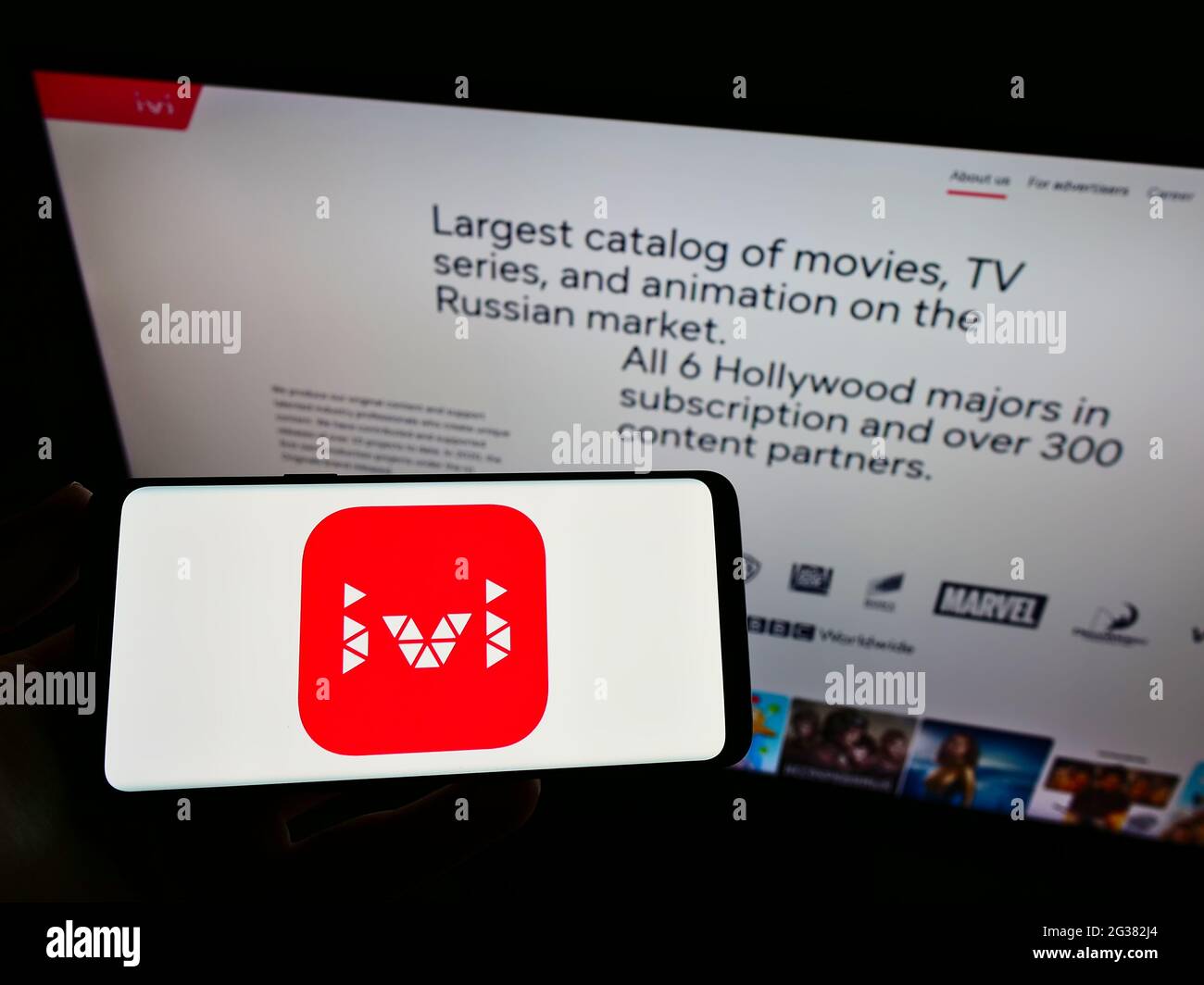 Person holding mobile phone with logo of Russian video streaming ...