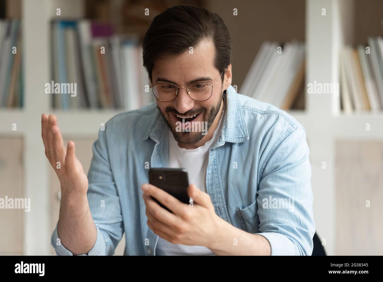 Surprised young man getting message with unbelievable news Stock Photo ...