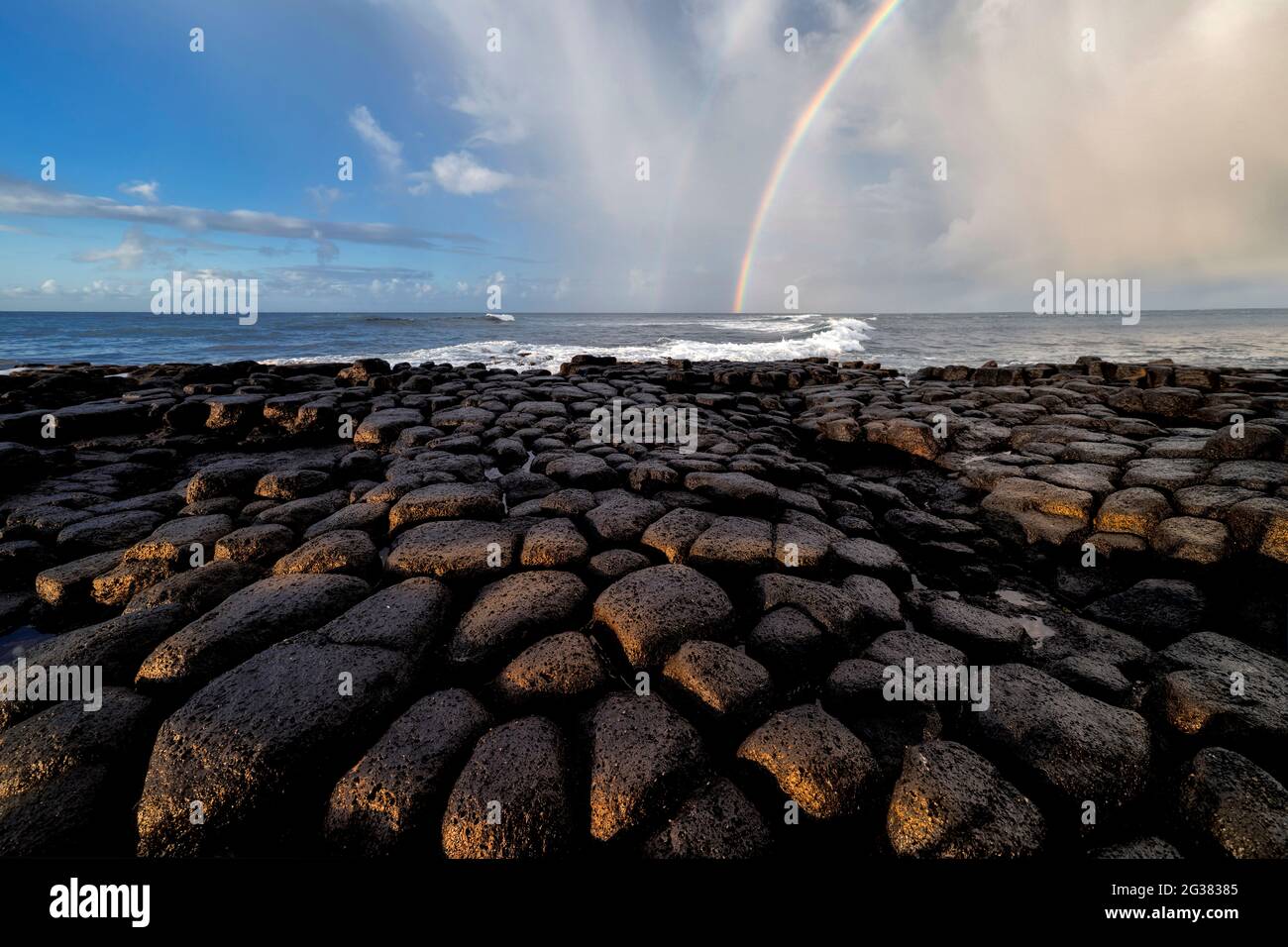 Basalt columns and rainbow with storm clouds. Kauai, Hawaii Stock Photo ...