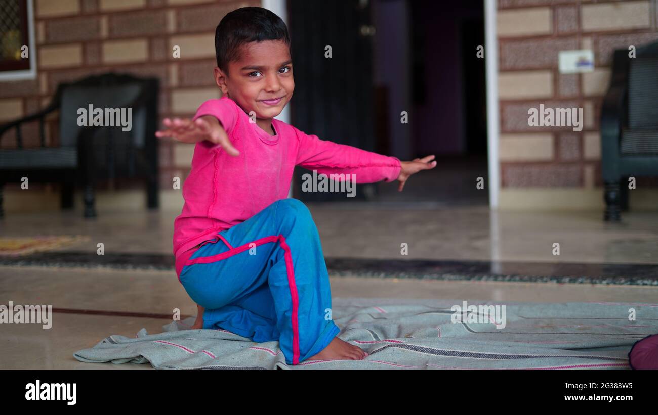 Kids yoga. Little Indian boy doing yoga exercise and watching ...
