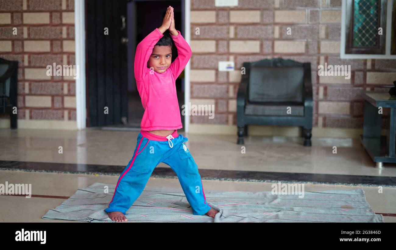 Kids yoga. Little Indian boy doing yoga exercise and watching ...