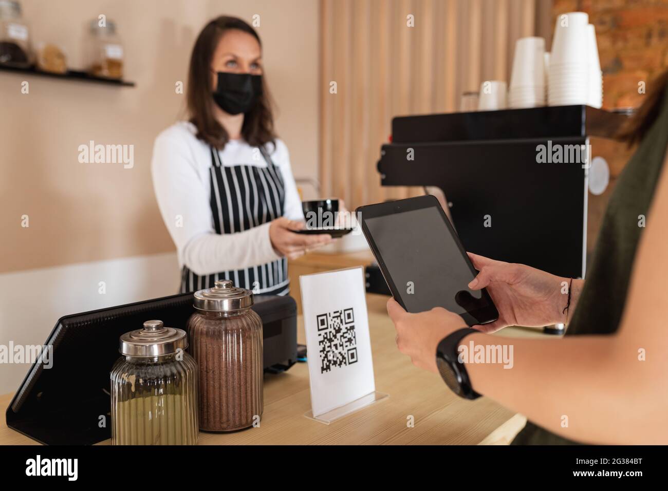 Caucasian female customer holding tablet, scanning qr code, taking ...