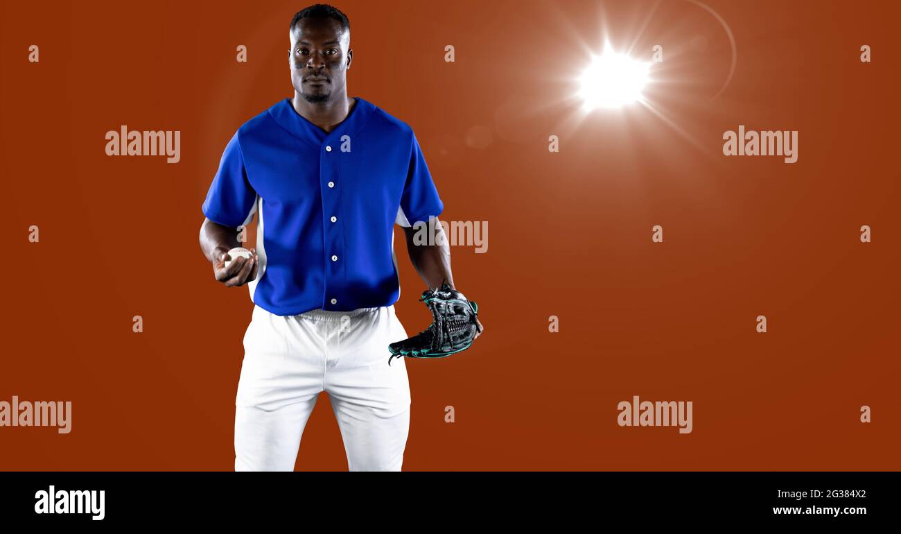 African american male baseball pitcher holding a ball against spot of ...