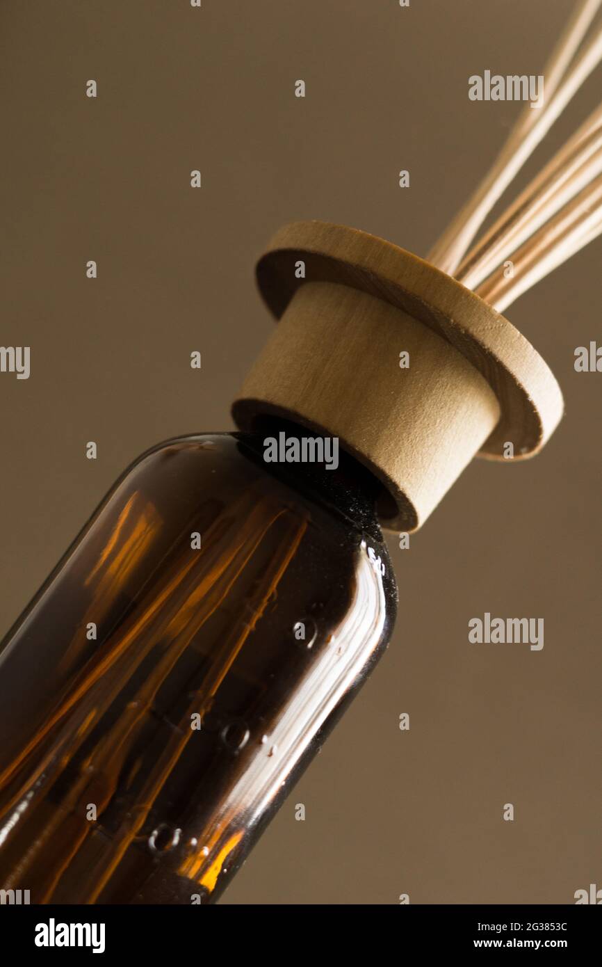 Dark glass diffuser bottle with natural reed sticks and a brown wood ...