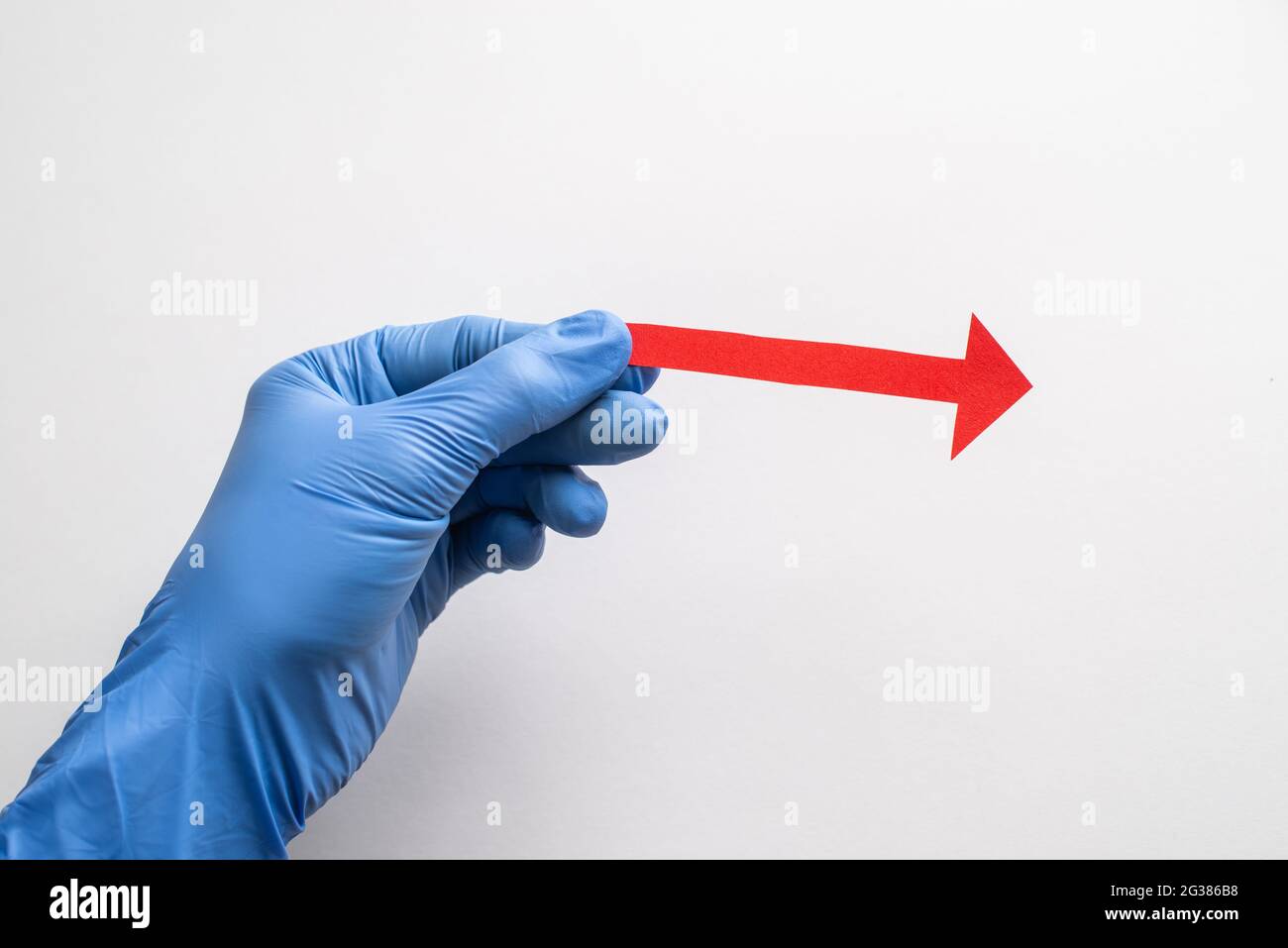Hand in glove holding a red paper arrow pointing to the right Stock ...