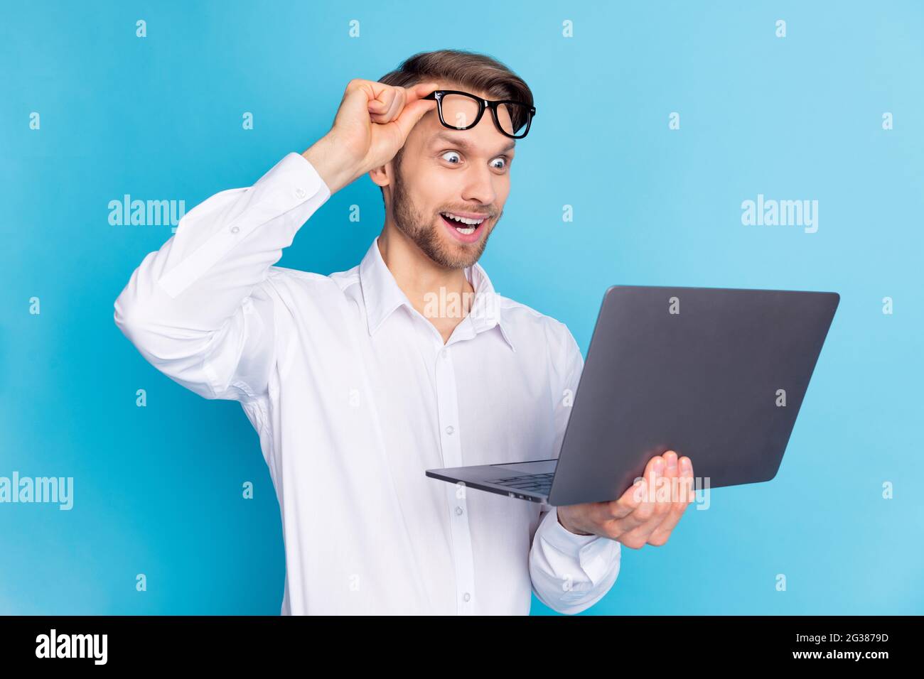 Photo of shocked astonished young man look screen computer wear glasses ...