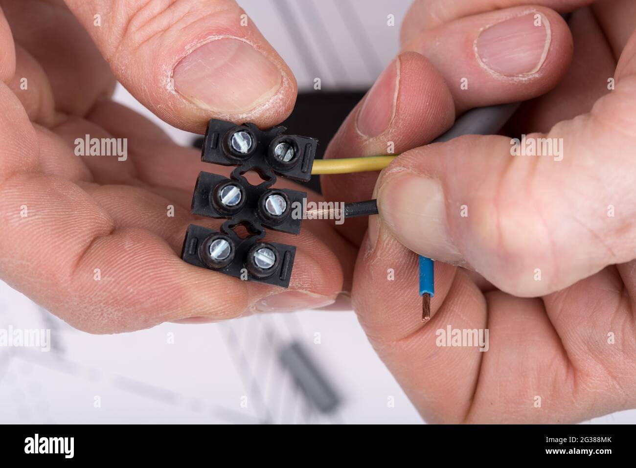 Hand putting a wire in a connector Stock Photo - Alamy