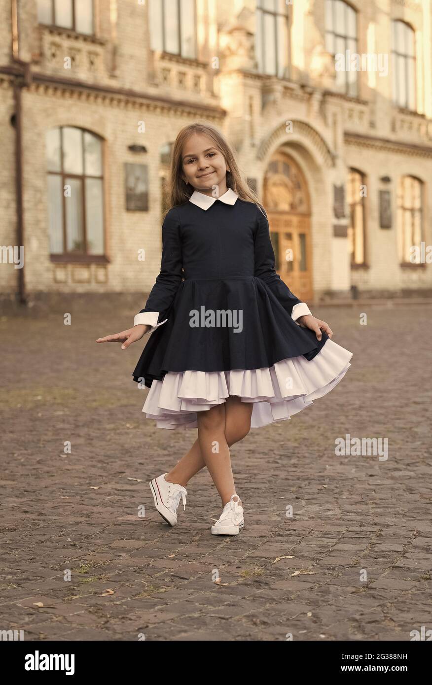 Its pleasure of elegance. Happy kid make curtsy in uniform outdoors ...