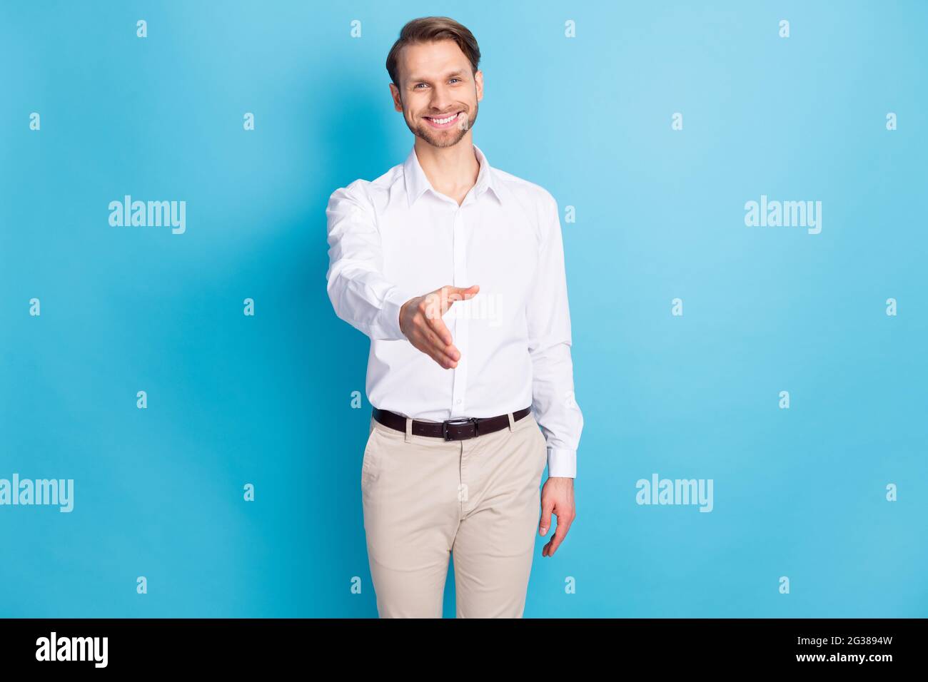 Photo of happy positive attractive young man shake hand you smile good ...