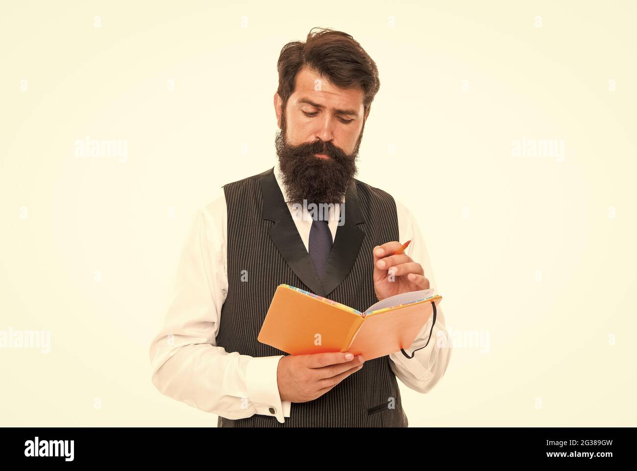 Concentrated bearded man write in school exercise book doing homework ...
