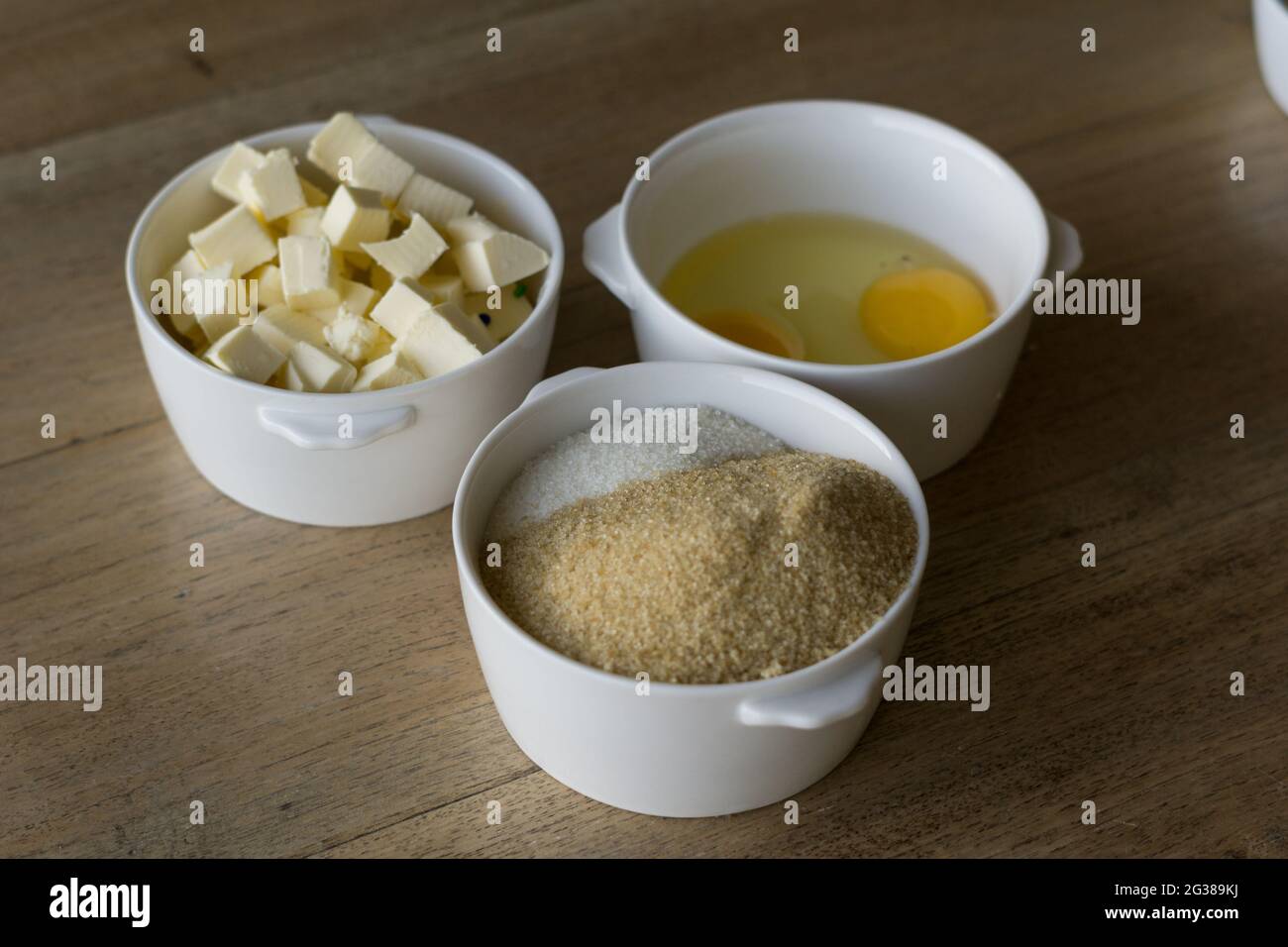Top view of different ingredients of a cookie in white bowls put on a ...