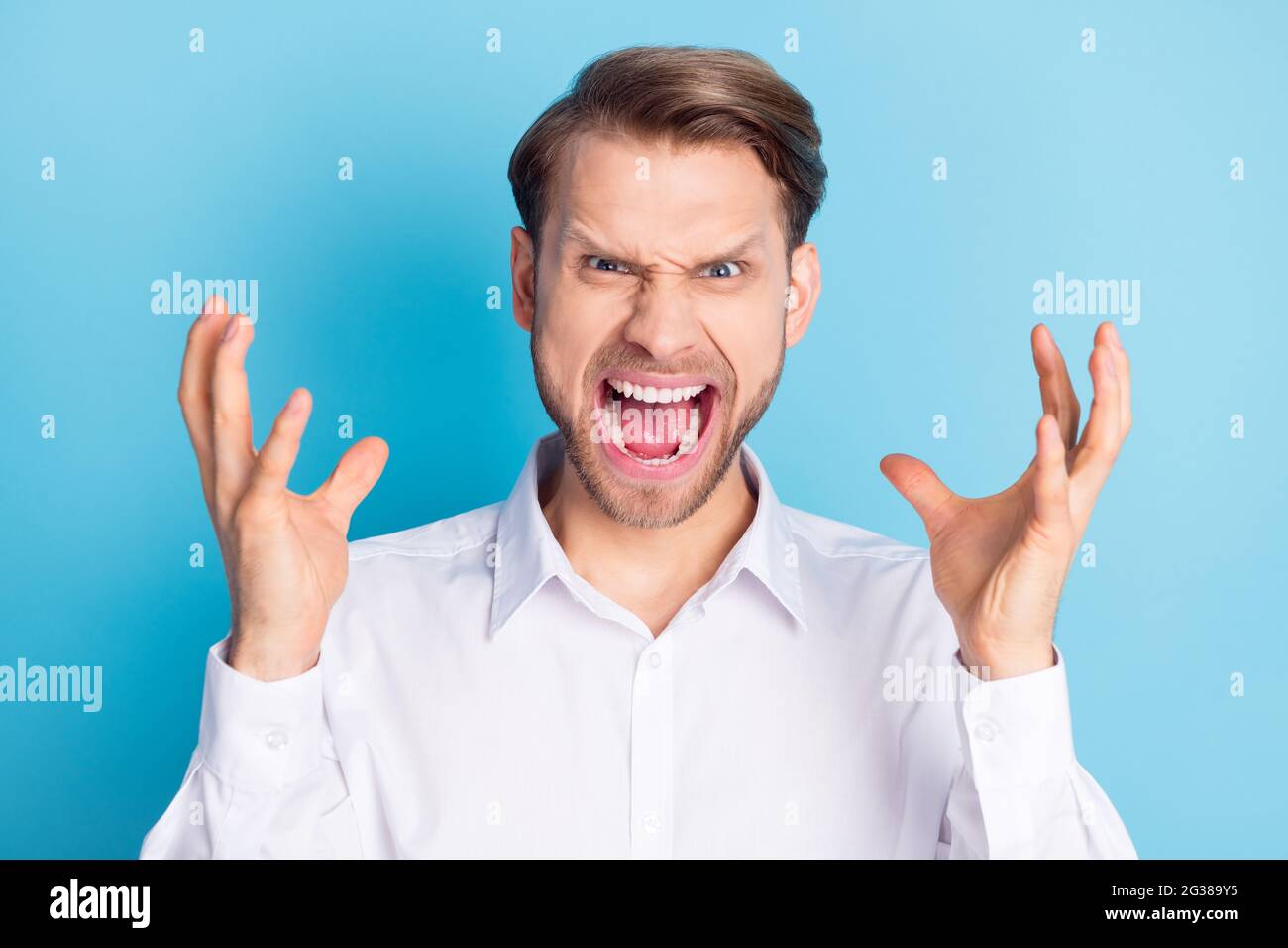 Photo of unhappy angry furious young man raise hands bad mood isolated ...