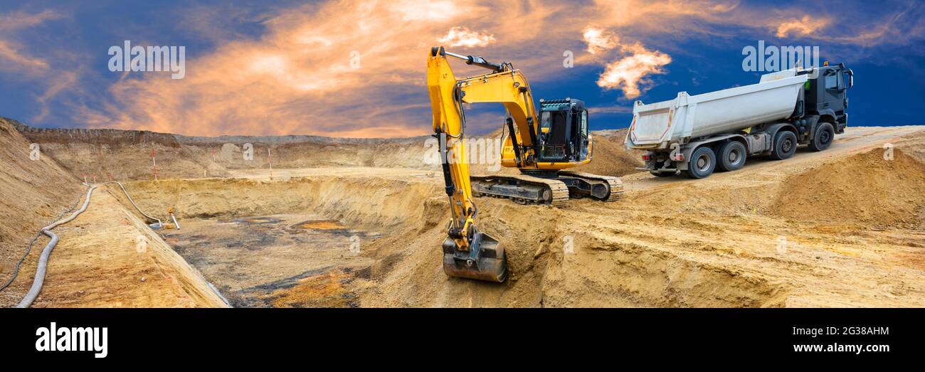 earth mover and excavator at work in construction site Stock Photo - Alamy
