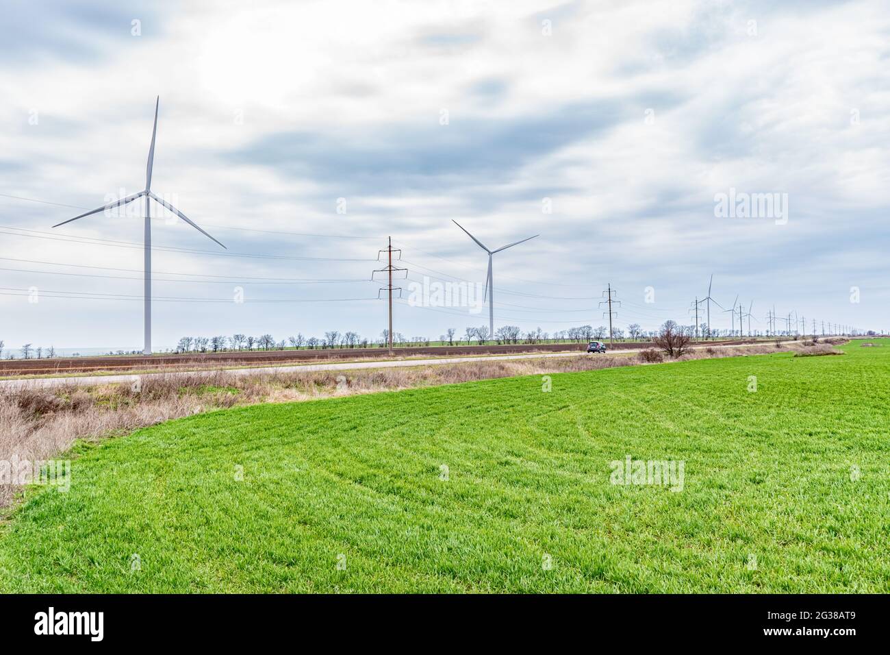 Wind turbines generating electricity in a green field. Green power ...