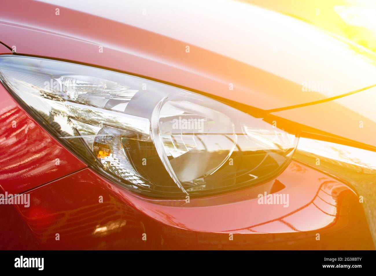 Closeup headlights of red car with sunlight Stock Photo - Alamy