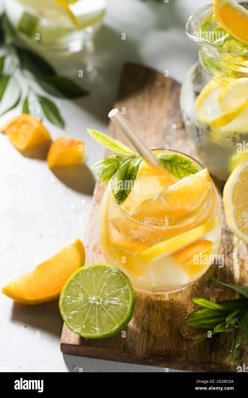 Refreshing lemonade with lemon and mint in a jug and glass on a wooden ...