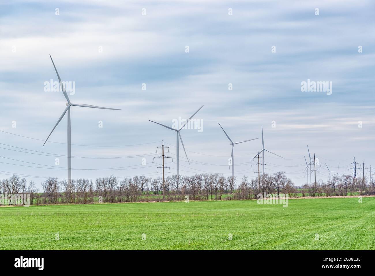 Wind turbines generating electricity in a green field. Green power ...