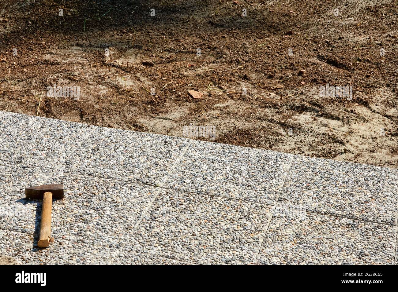 Garden brick path paving with hammer. Laying concrete paving slabs in ...