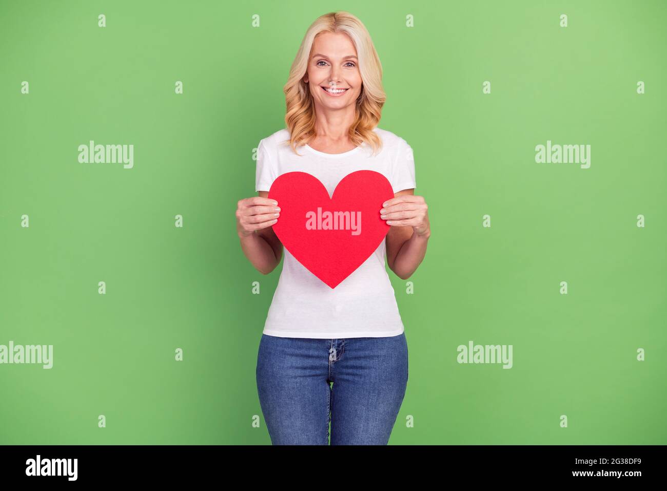 Photo of flirty blond senior lady hold heart wear white t-shirt ...