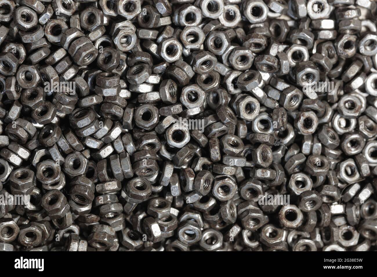 Many old used screw-nuts background, dark shining nuts Stock Photo - Alamy