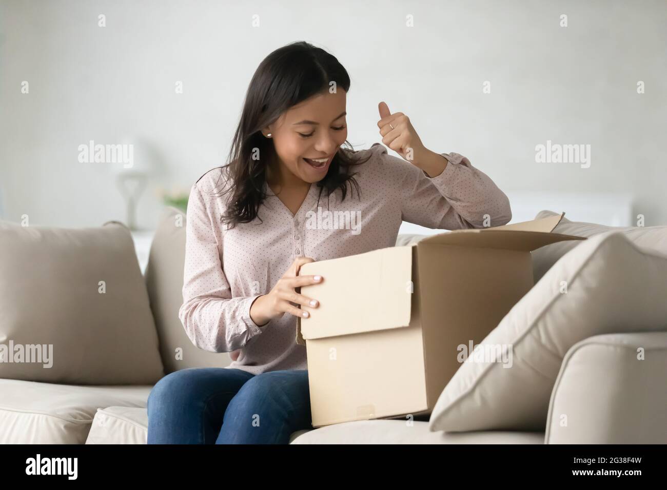 Happy excited parcel recipient unpacking received box Stock Photo - Alamy