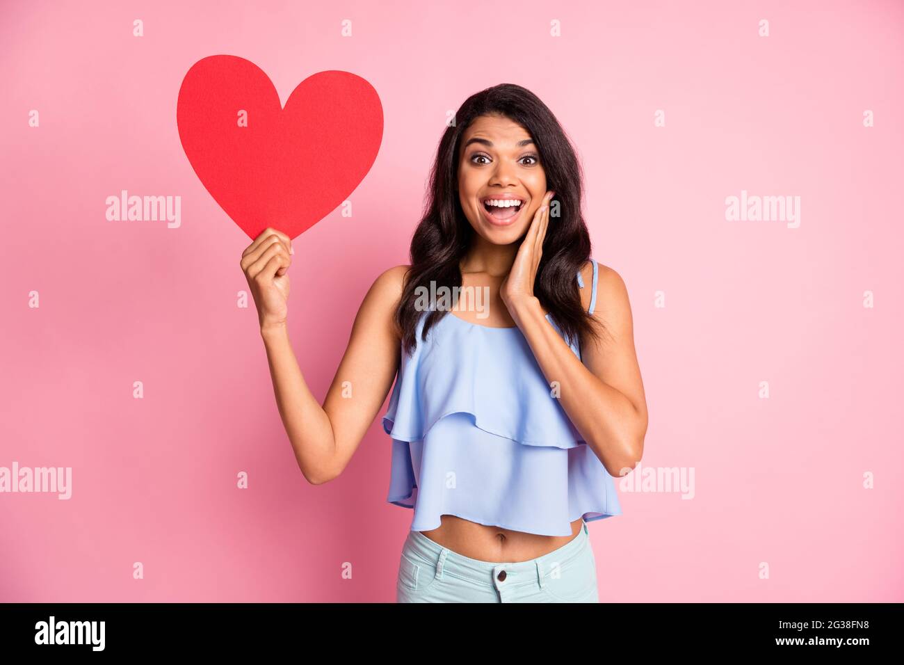 Photo of impressed brunette lady hand face show paper heart wear blue ...