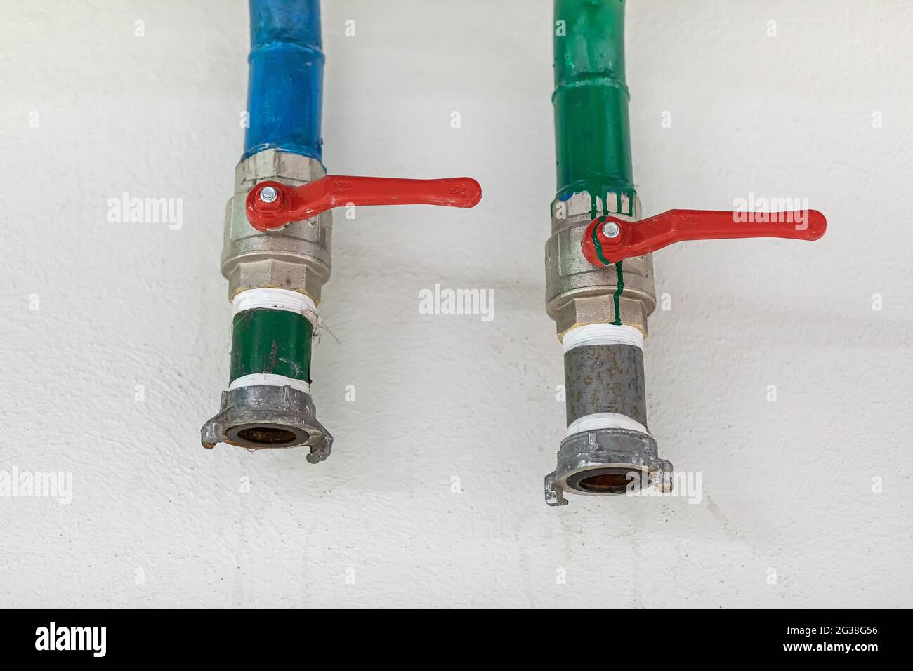 Two water tap with red valve handle inside building, at home. Fire ...